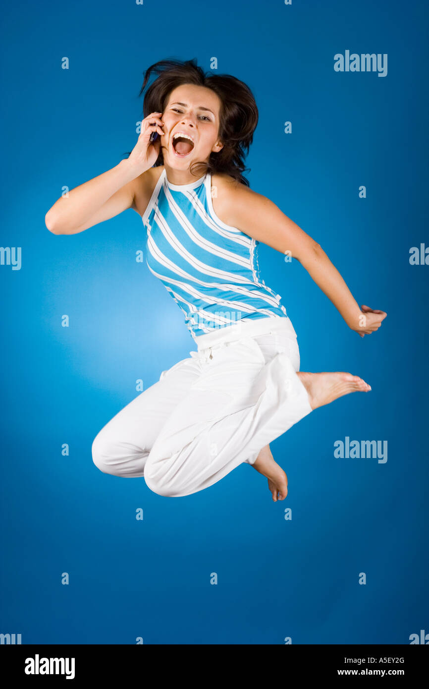jumping happy woman with cell phone Stock Photo - Alamy