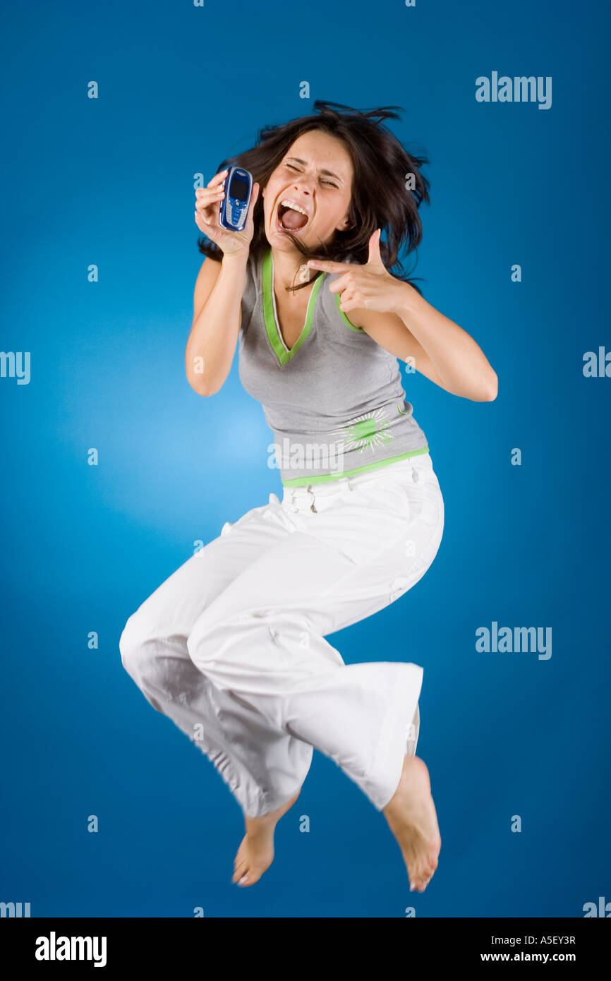 jumping happy woman with cell phone Stock Photo - Alamy