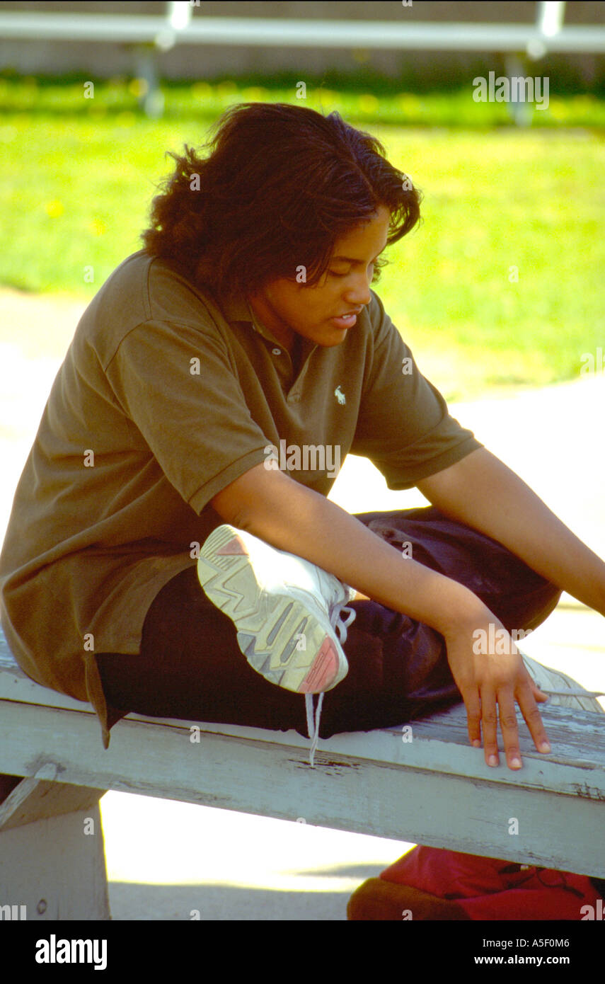 Teen girl age 18 sitting with legs crossed on table. St Paul Minnesota ...
