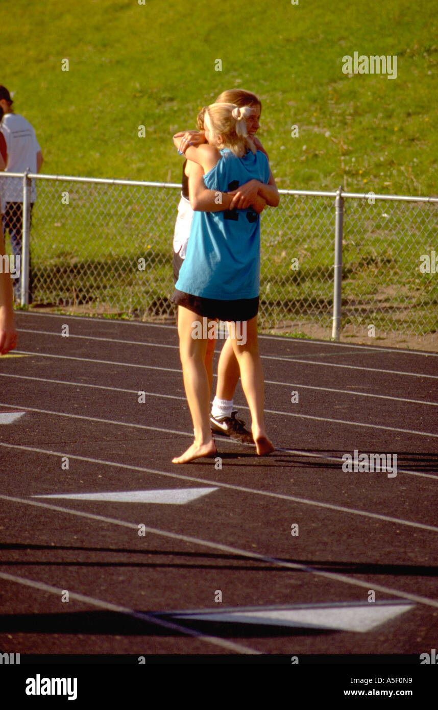 Friends hugging at high school track meet age 16. Minnetonka Minnesota ...