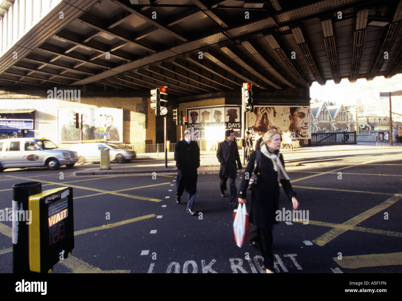 People crossing a street under the bridge Stock Photo - Alamy
