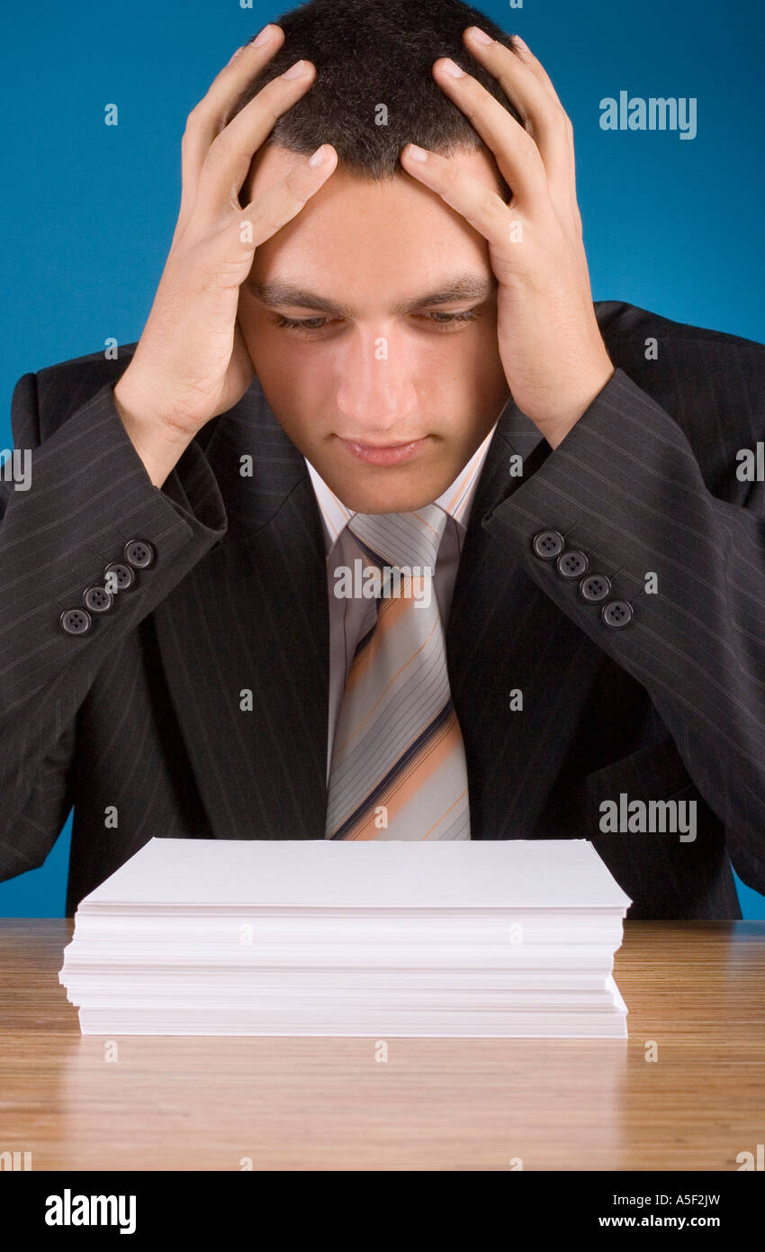 shocked businessman at the stack of documents blue background Stock ...