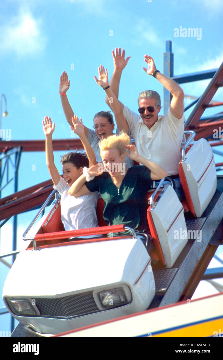 Family riding roller coaster at state fair with arms up age parents 40 ...