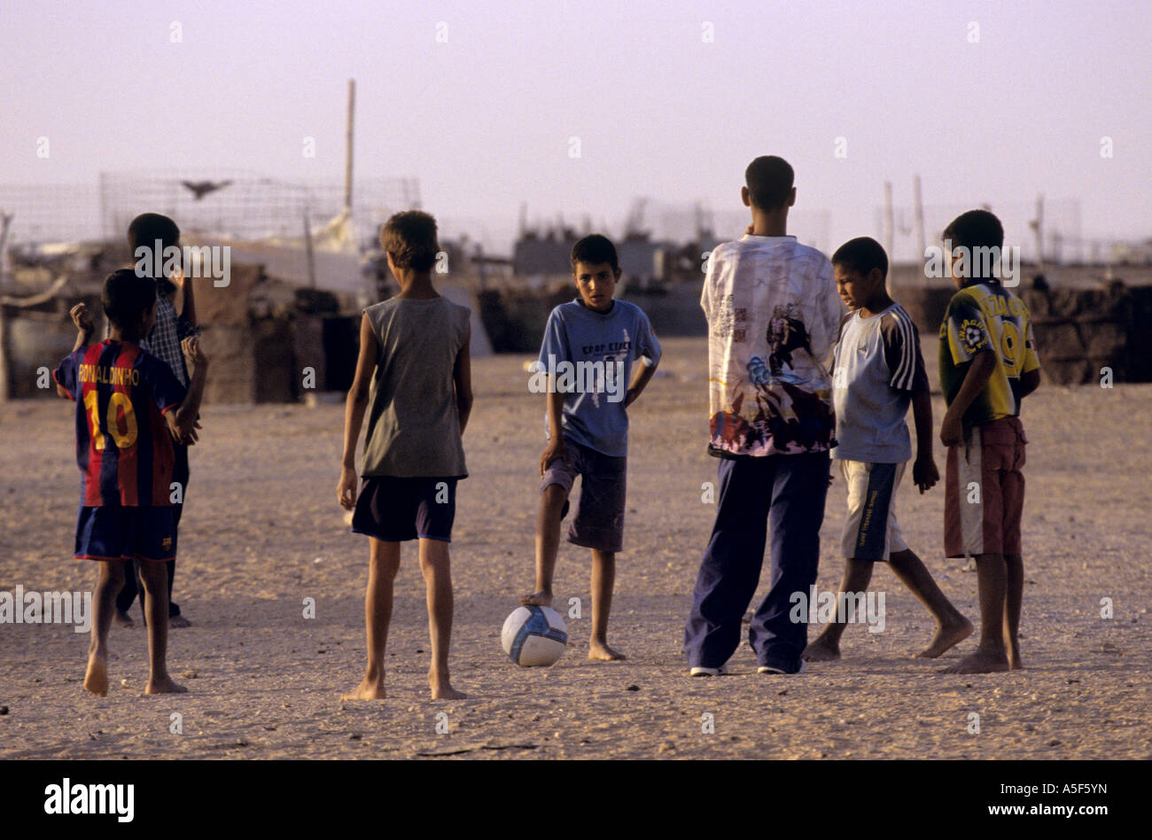 A group of Saharawi refugee children playing soccer at a refugee camp ...