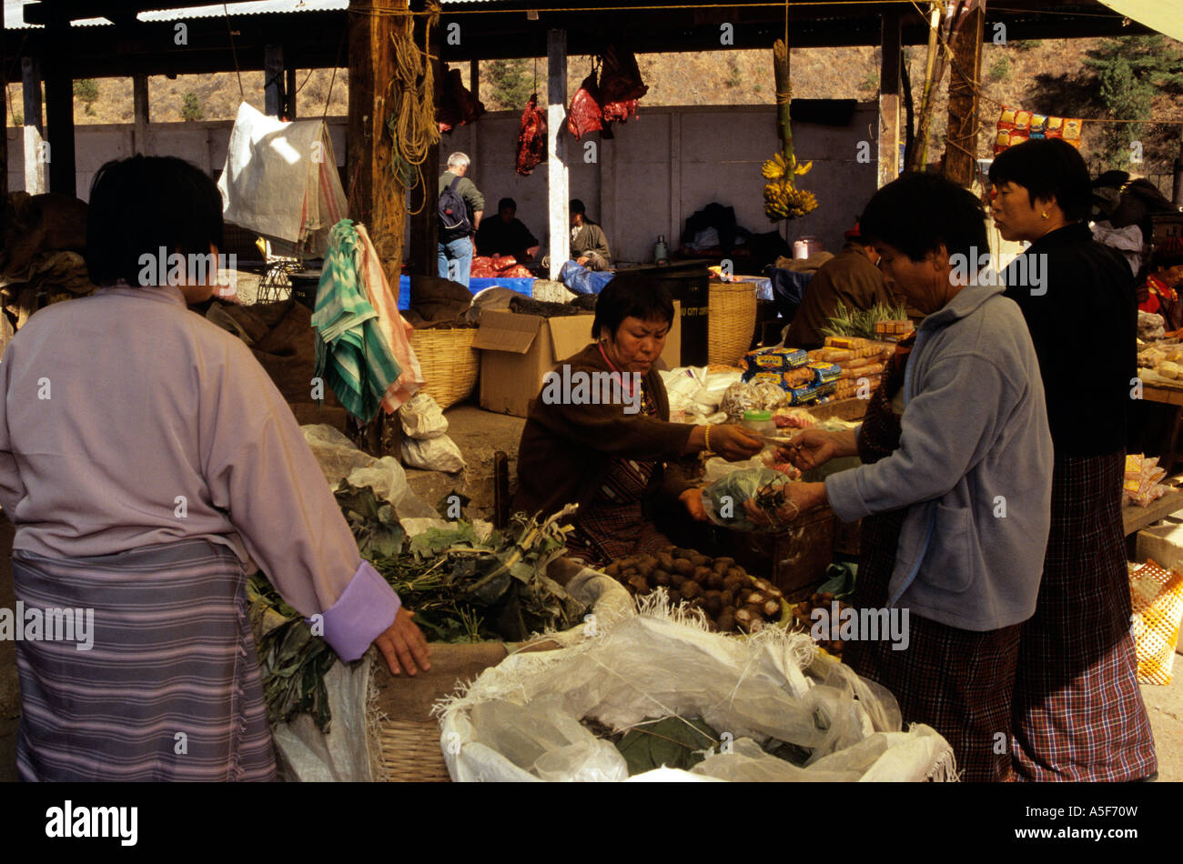 Vegetable vendor busy serving customers at stall in market, Thimpu ...