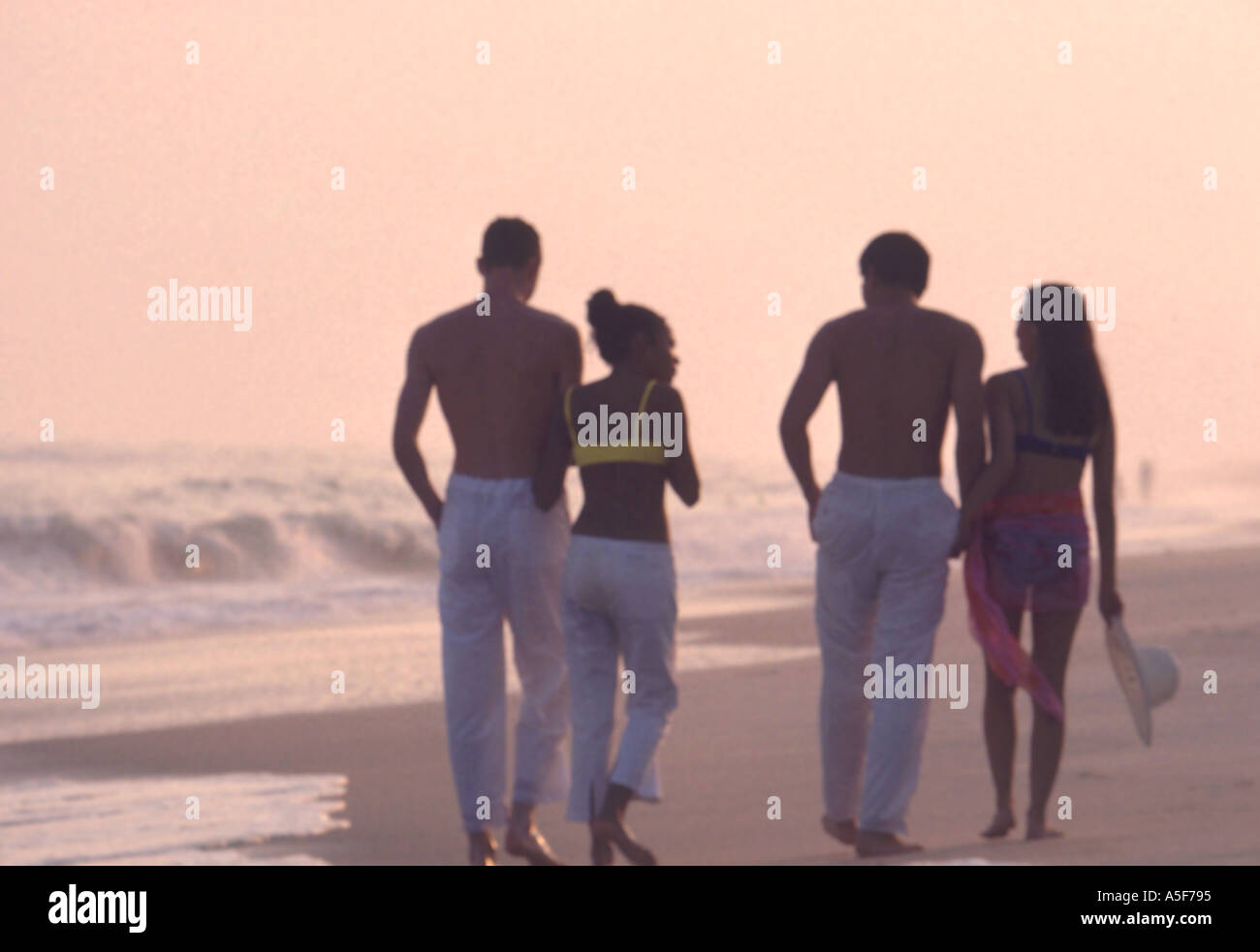 Couples Walking on a Beach Stock Photo - Alamy