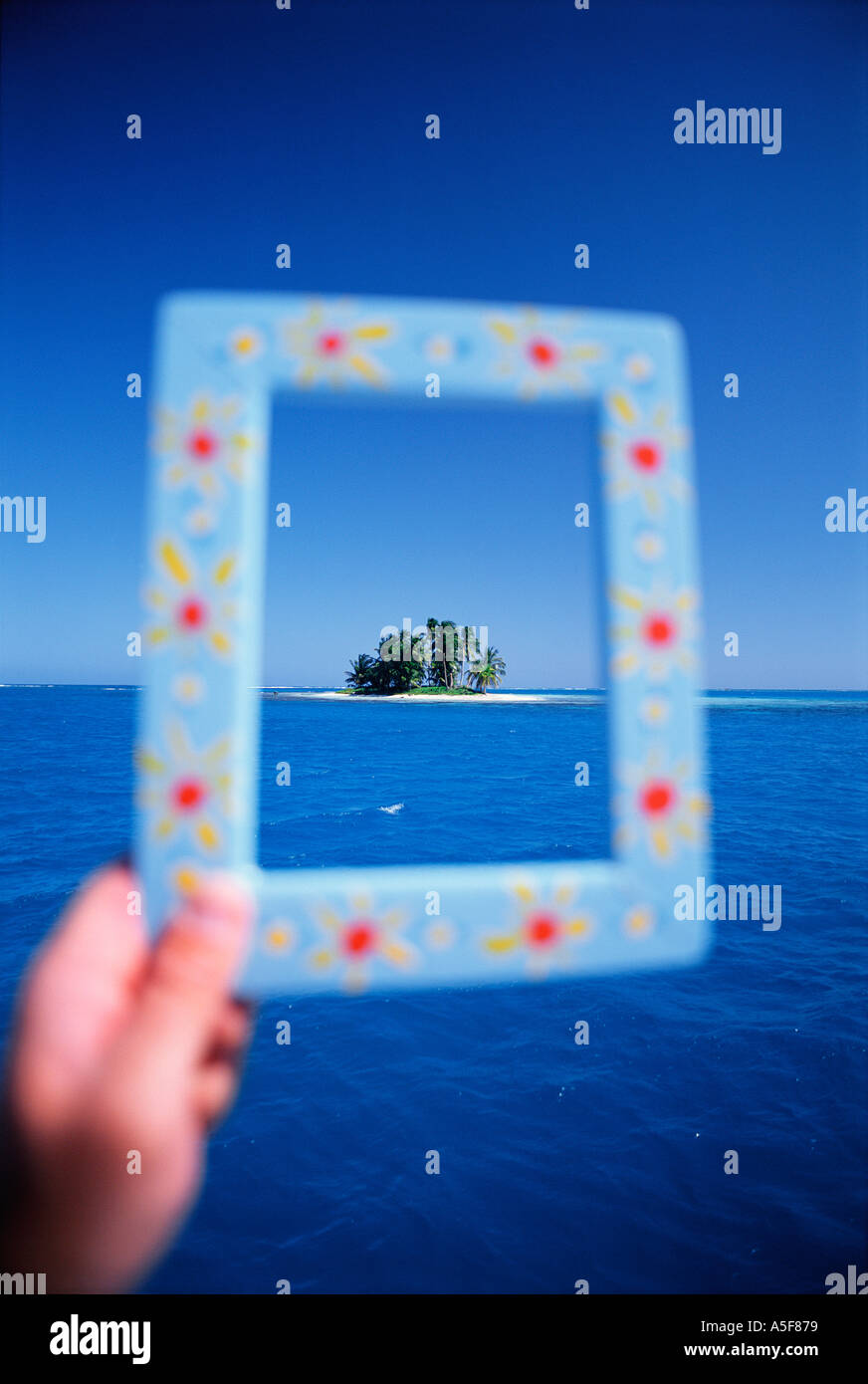 Hand holding frame showing small tropical island in Belize Central ...