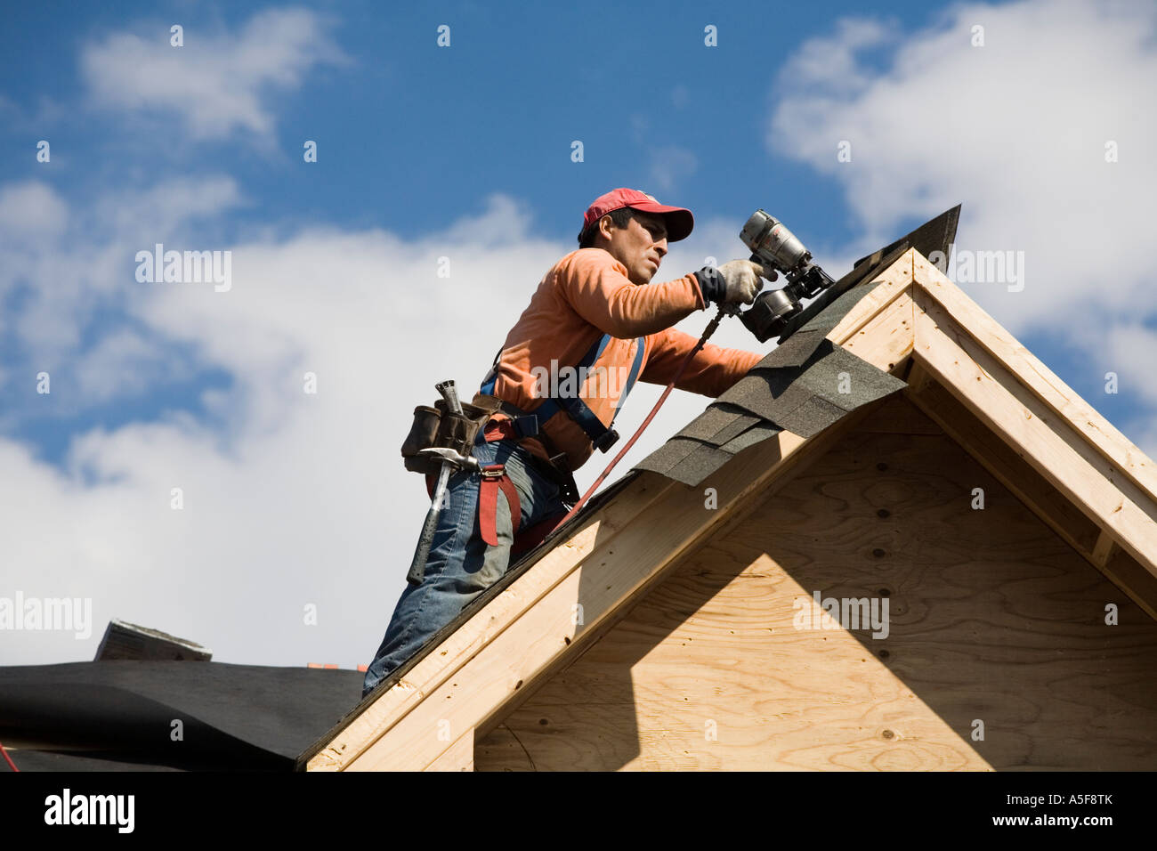 Immigrant Worker Installing Roof Shingle Stock Photo - Alamy