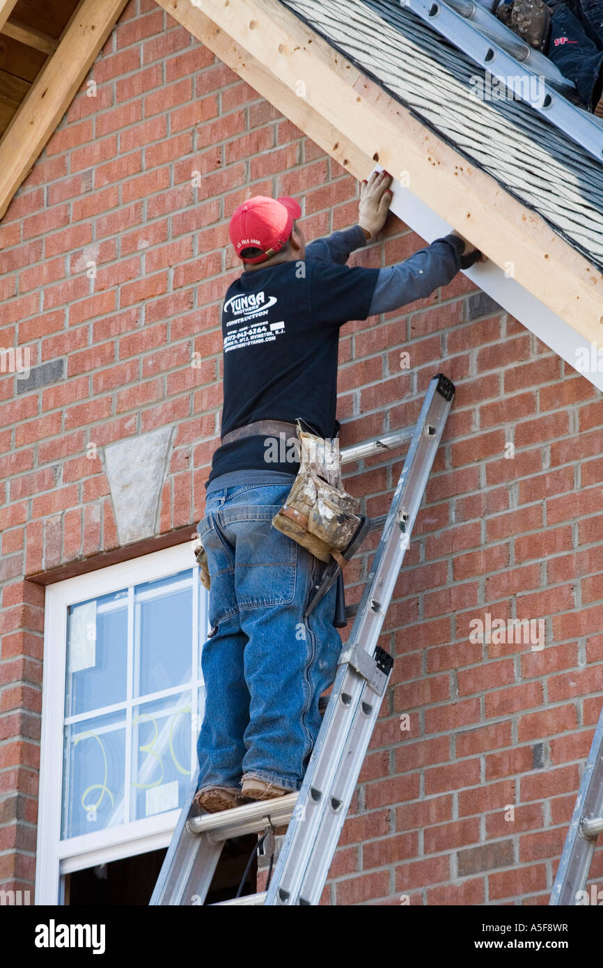 Immigrant Worker Installing Vinyl Siding Stock Photo - Alamy