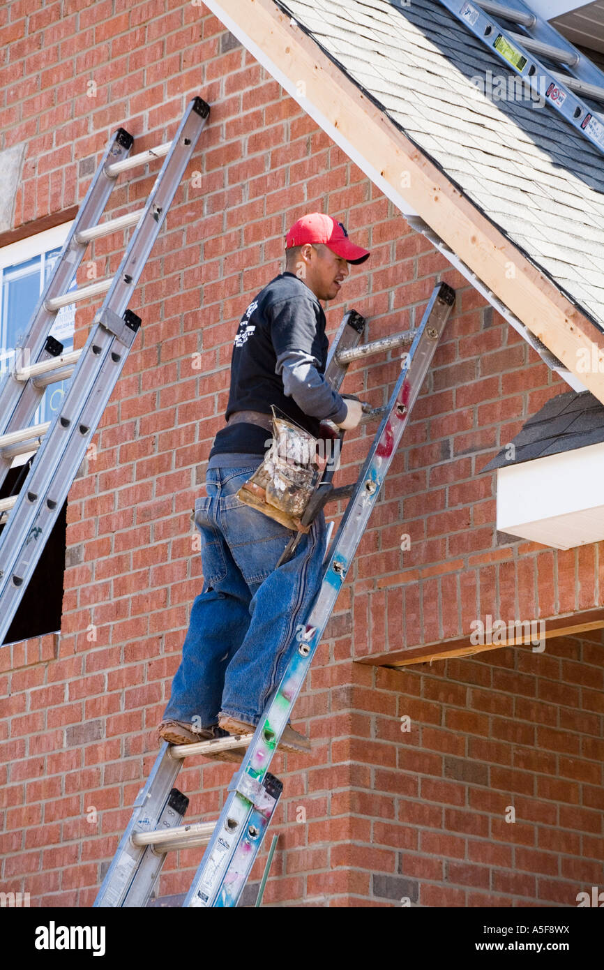 Immigrant Worker Installing Vinyl Siding Stock Photo - Alamy