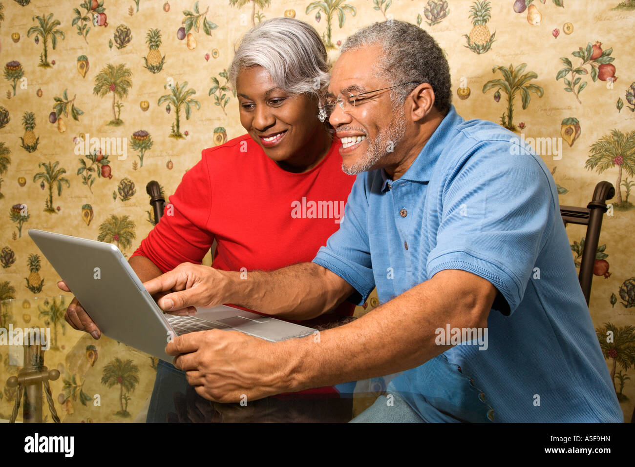 Portrait of mature African American couple looking at laptop in home ...