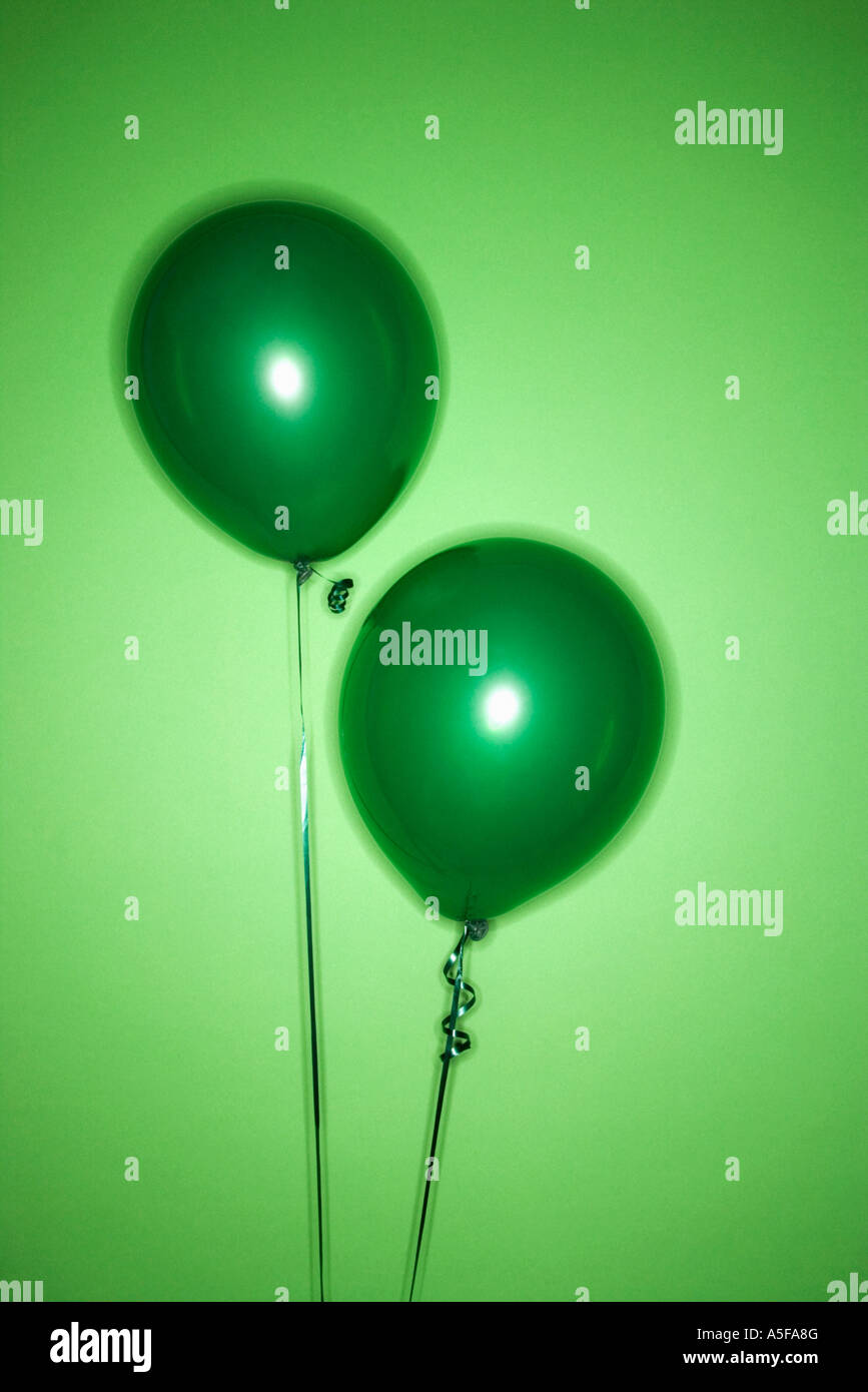 Still life of green balloons on green background Stock Photo - Alamy