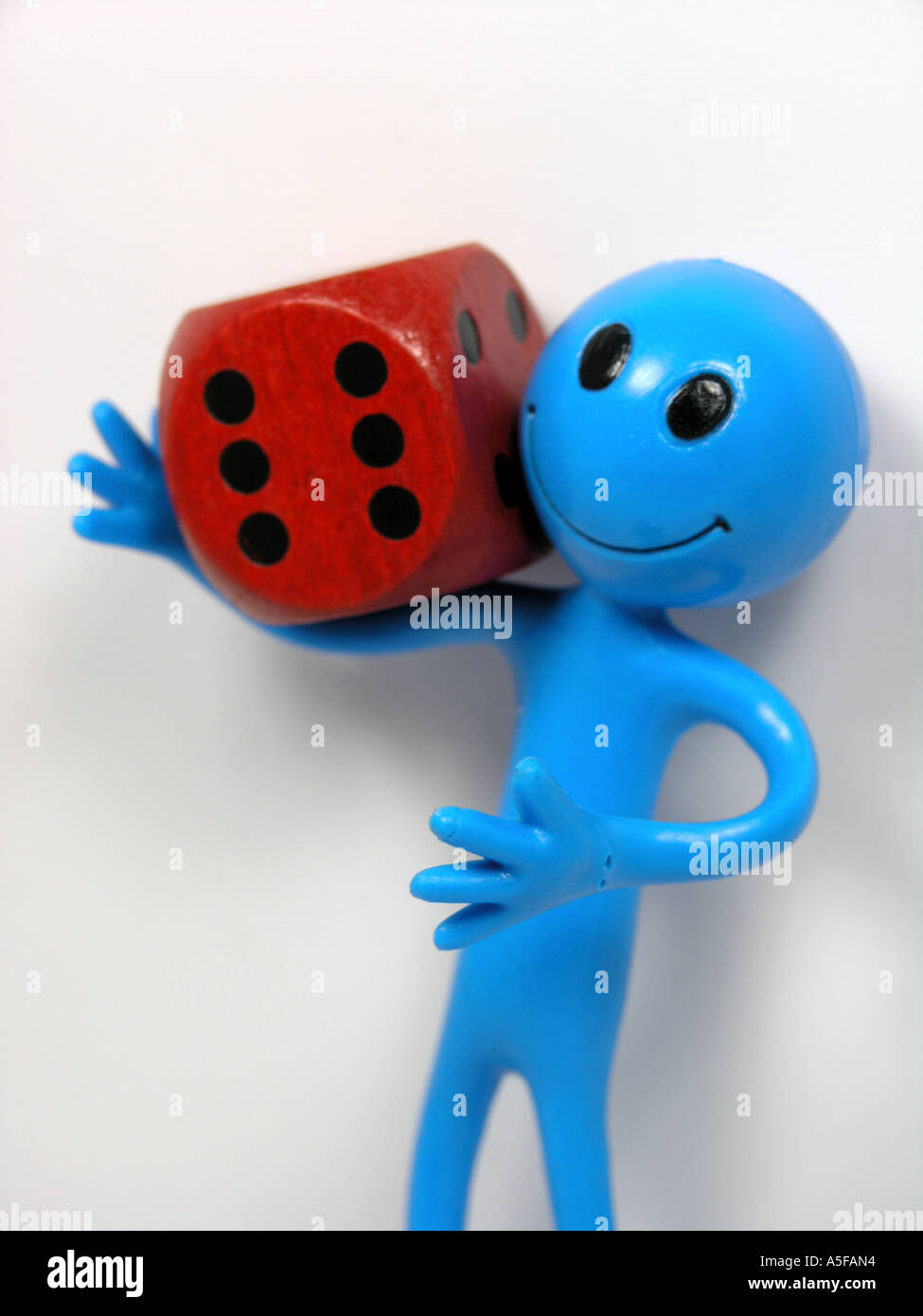 Blue bendy toy man with red dice Stock Photo - Alamy