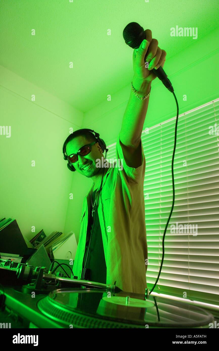 Smiling Asian young adult male DJ wearing sunglasses and holding ...