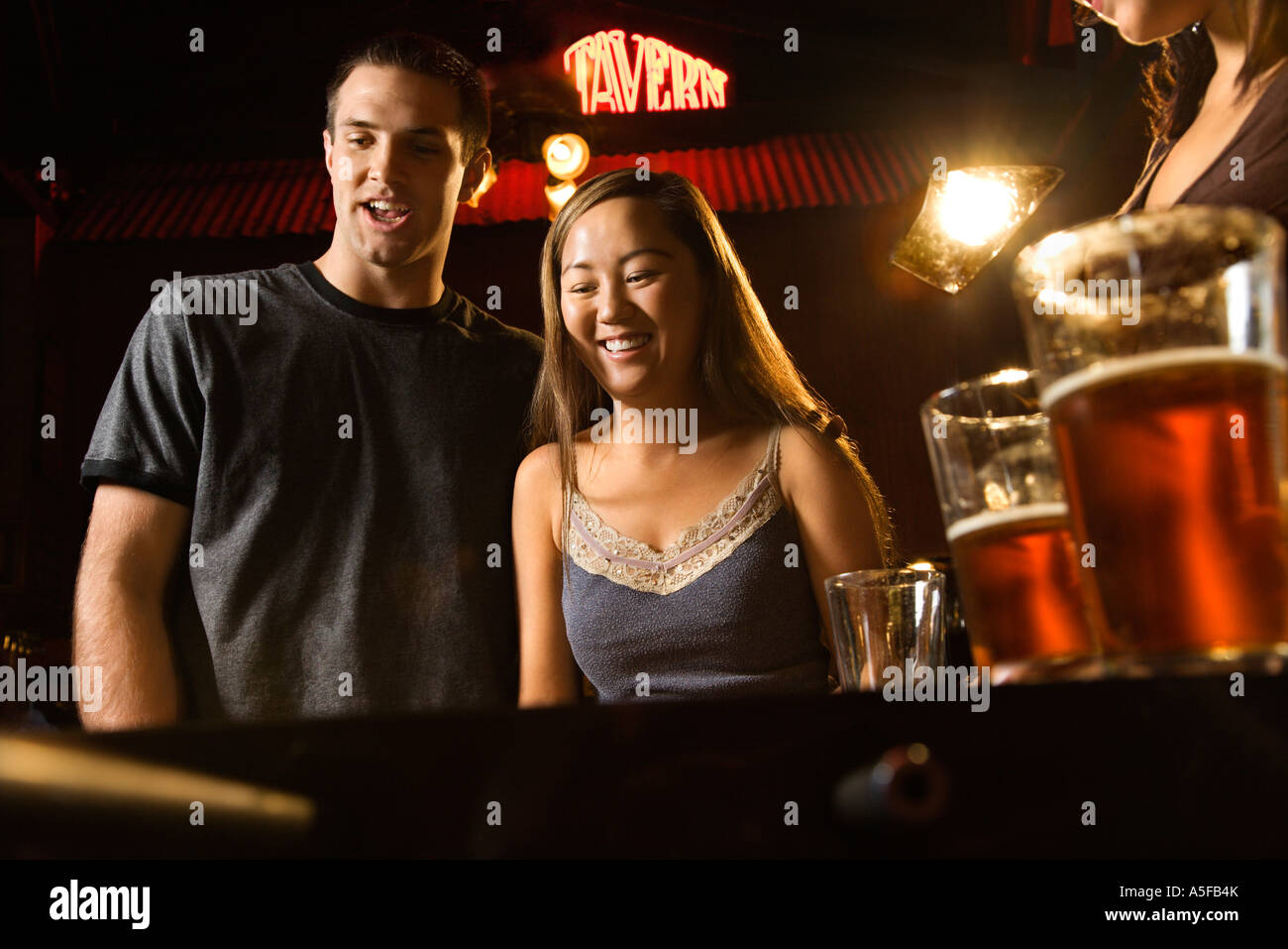 Young couple teamed up at foosball game in pub Stock Photo - Alamy