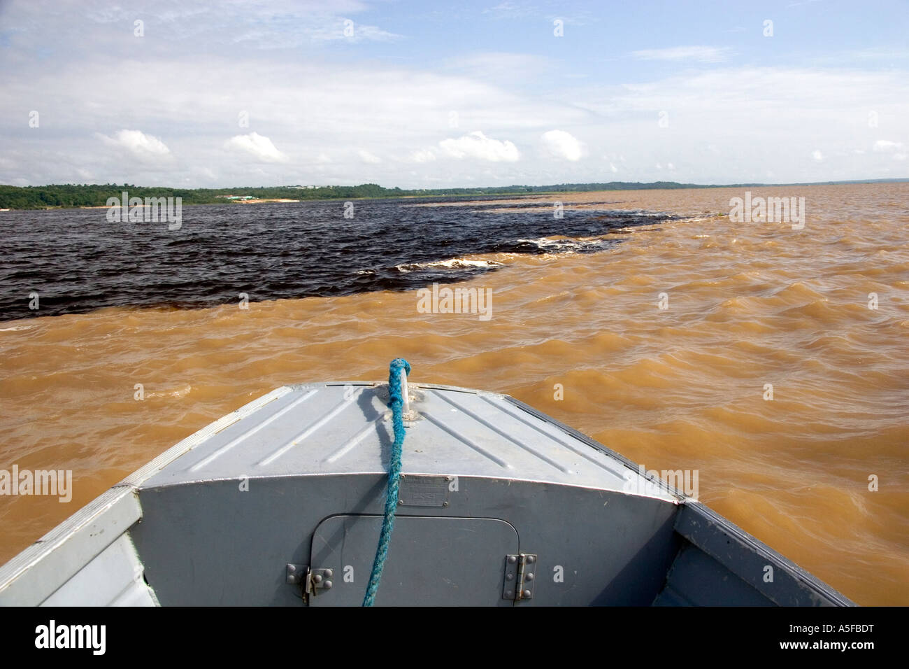 The bow of a boat at the confluence of the Amazon River and the Rio ...