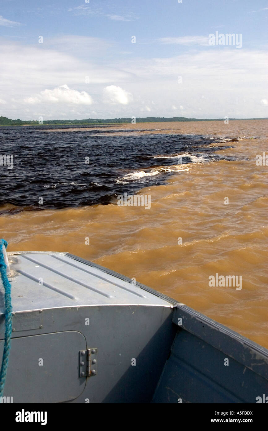 The bow of a boat at the confluence of the Amazon River and the Rio ...