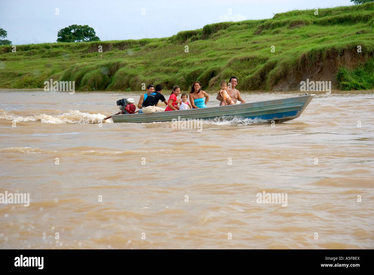 Brazilian people ride in a small river boat on the Amazon River near ...