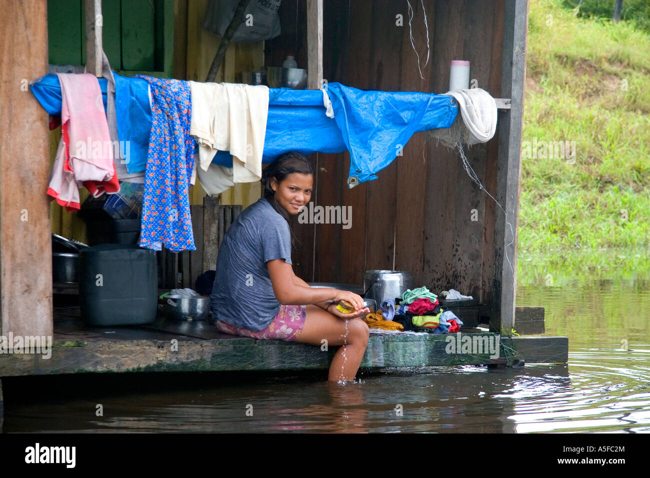 Brazilian girl washing clothes in the Arasa River in the Amazon jungle ...