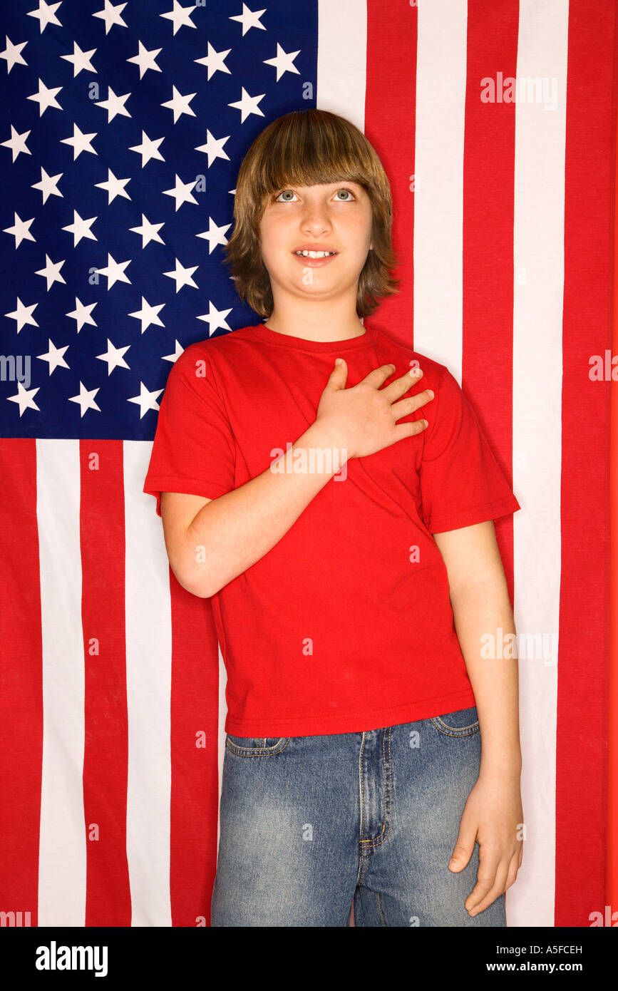 Portrait of Caucasian boy with hand over heart with american flag ...