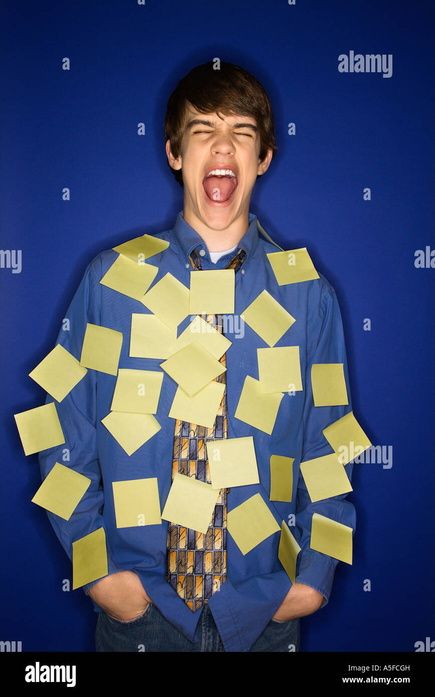 Portrait of Caucasian teen boy covered with sticky notes and screaming ...