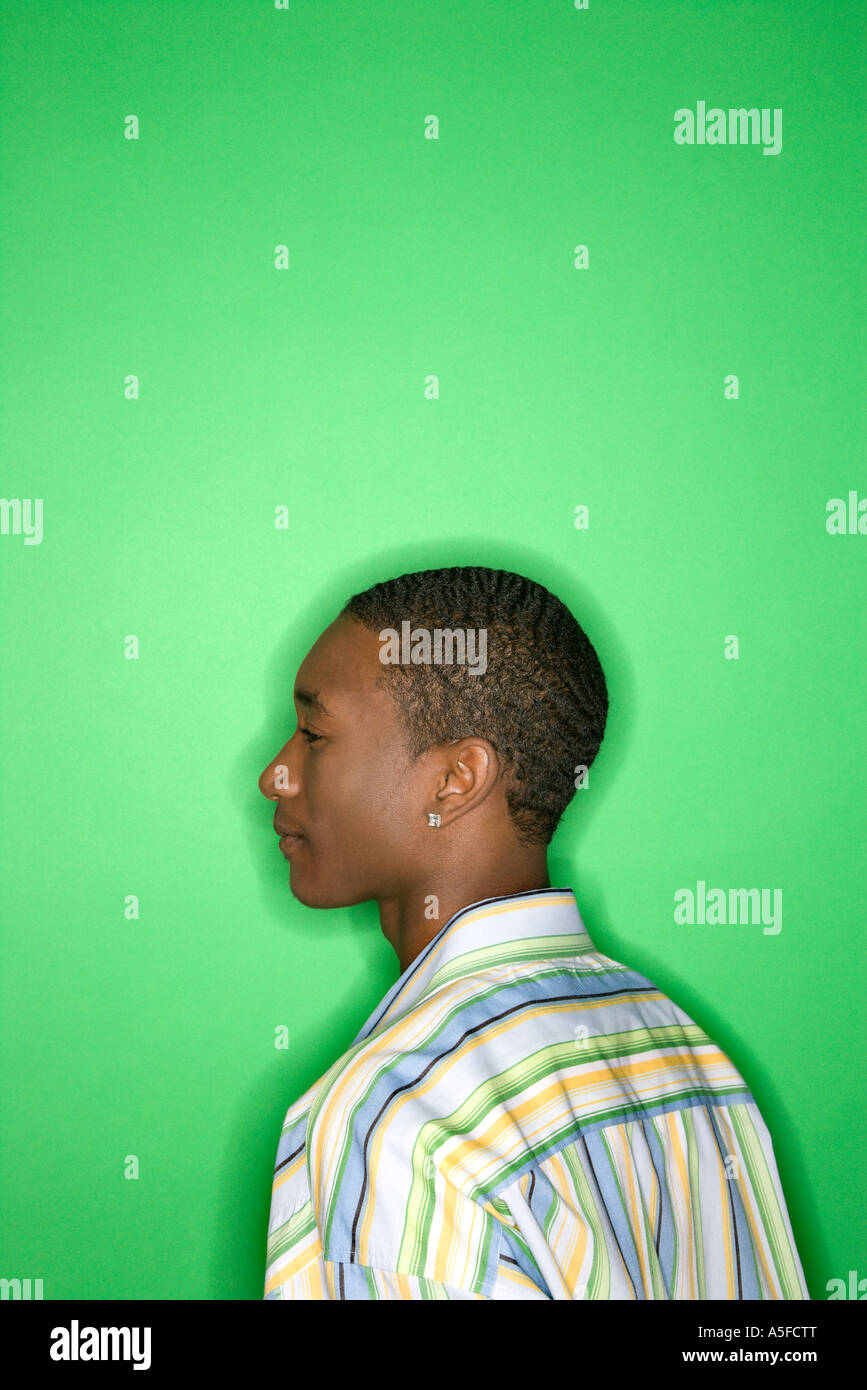 Side view portrait of African American teen boy against green ...
