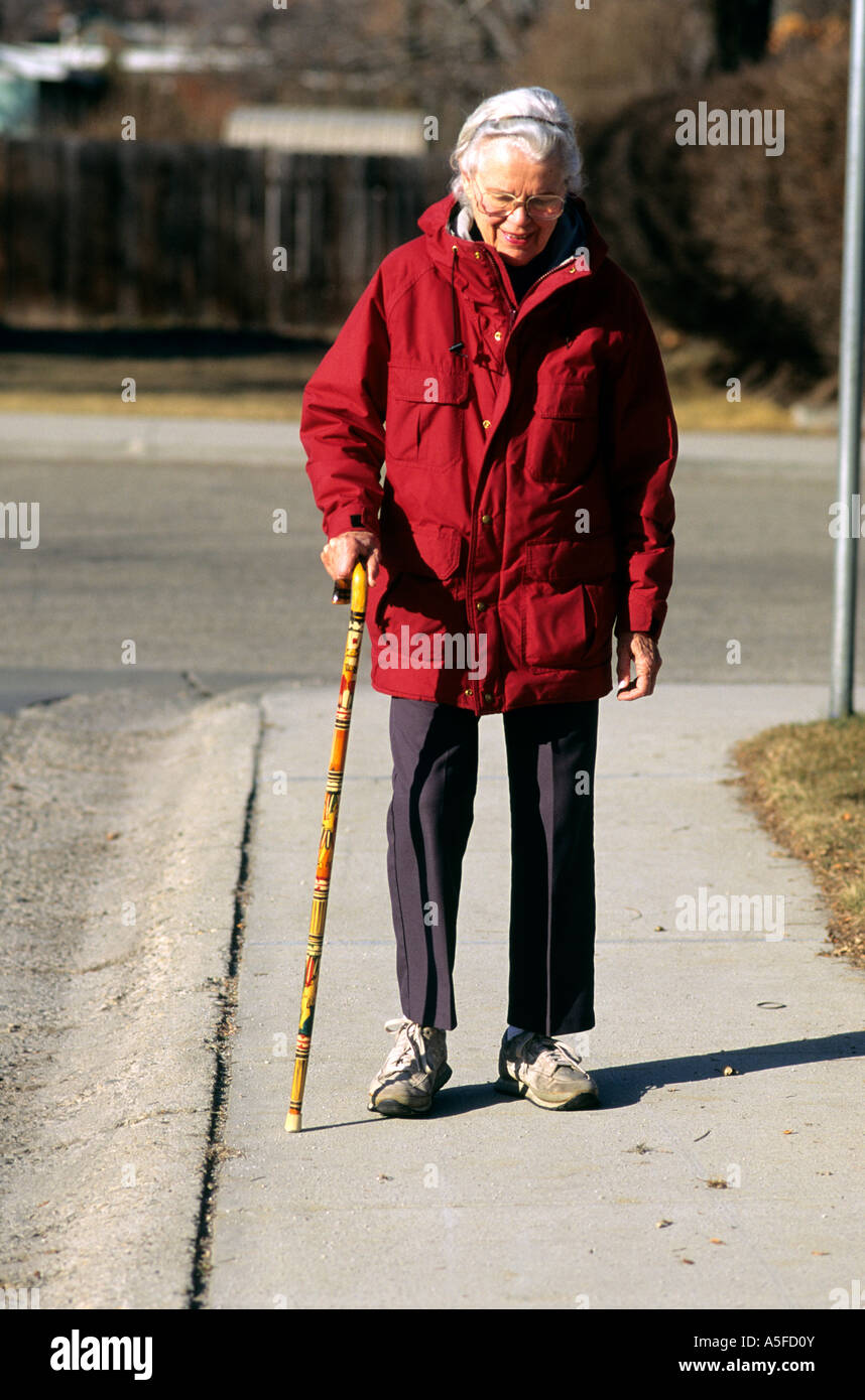 Elderly woman walking with a cane Stock Photo - Alamy