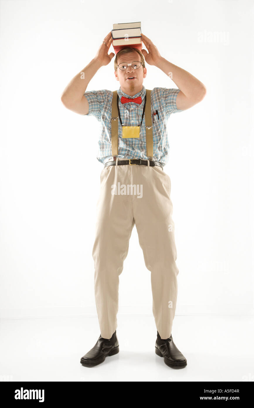 Caucasian young man dressed like nerd balancing books on head looking ...