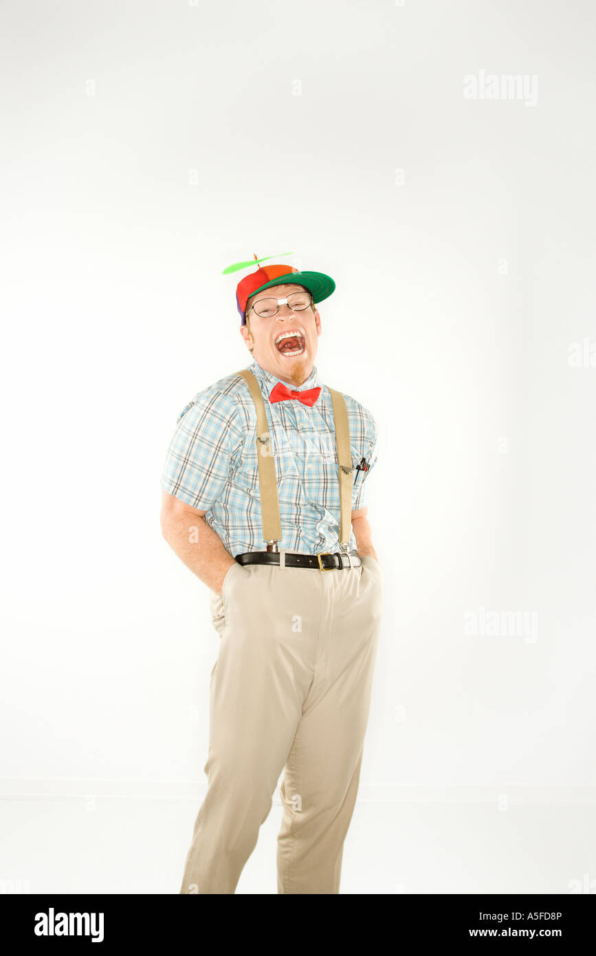 Caucasian young man dressed like nerd wearing propeller cap with hands ...