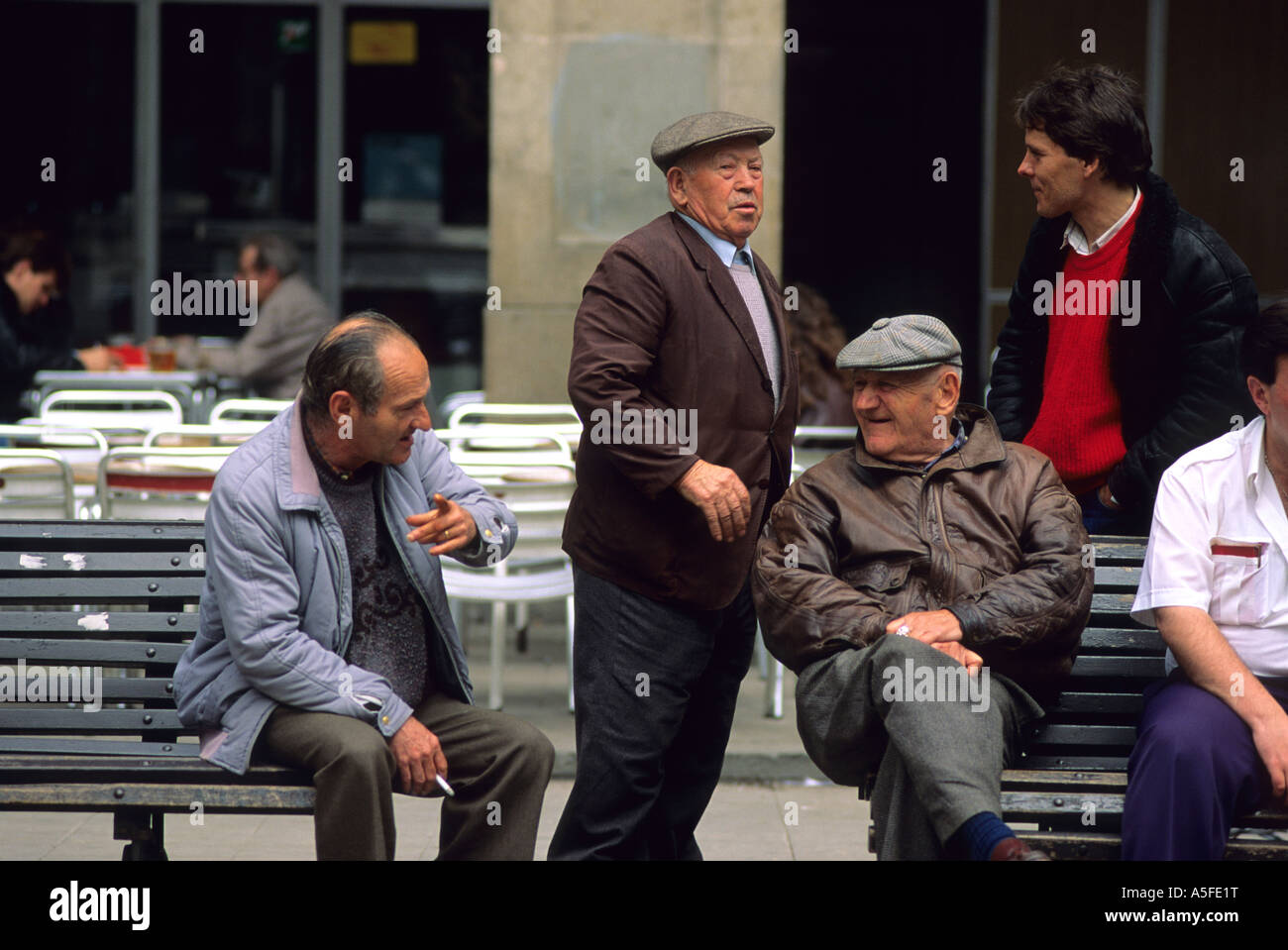 Elderly Spanish Men Have Conversation On The Streets Of Barcelona Spain