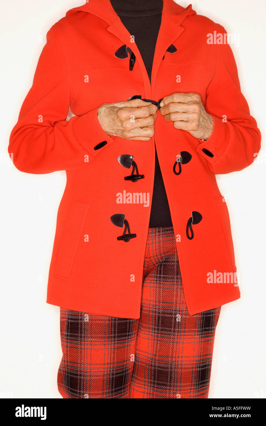 Caucasian mature adult female buttoning coat Stock Photo - Alamy