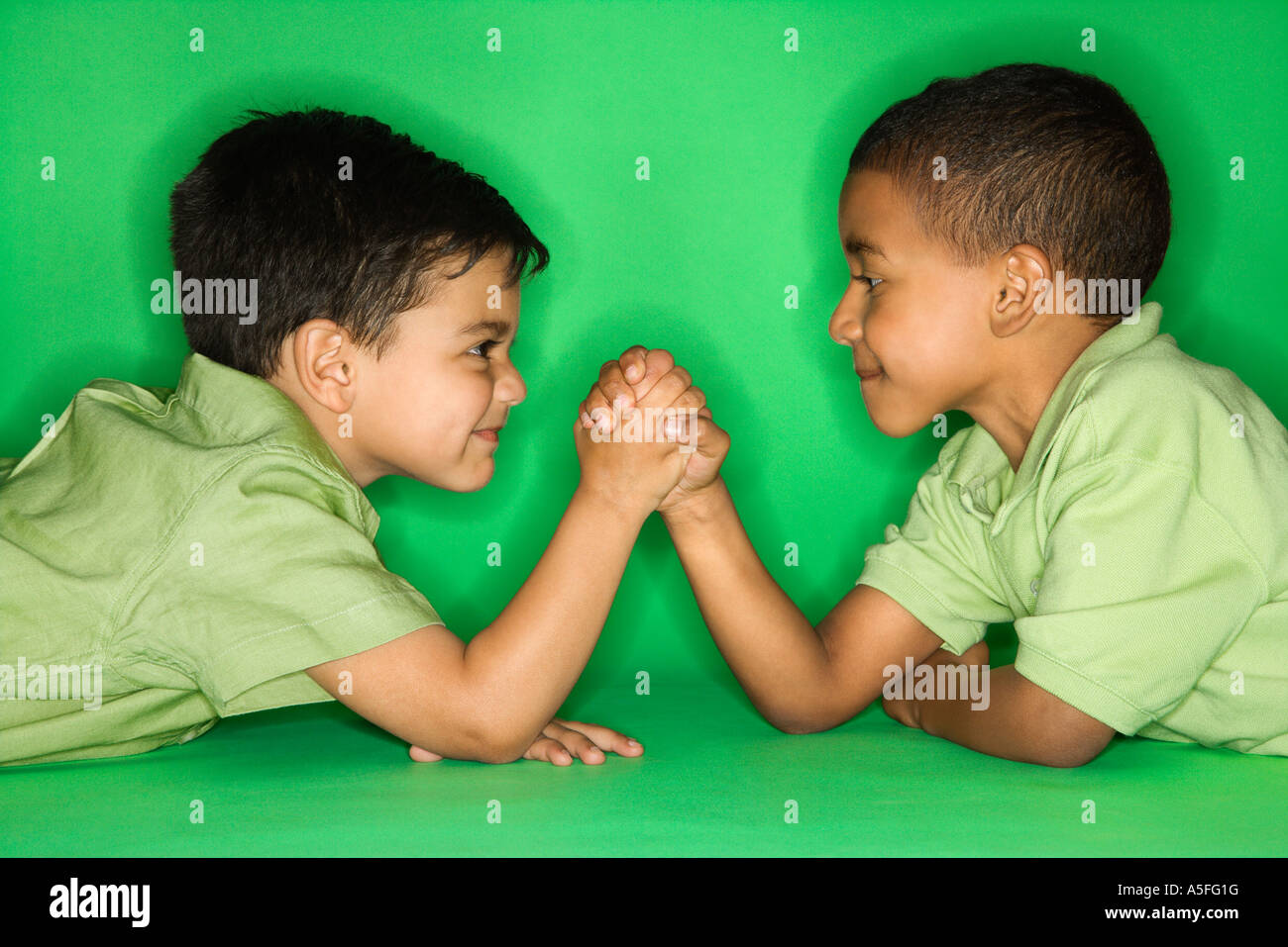 Hispanic and African American male child arm wrestling Stock Photo - Alamy