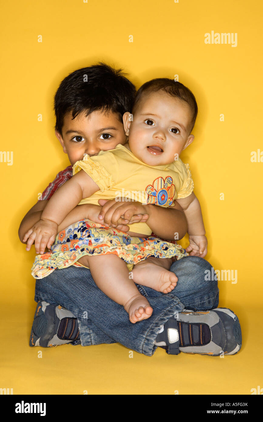 Hispanic and African American male child in cowboy hats shaking hands ...
