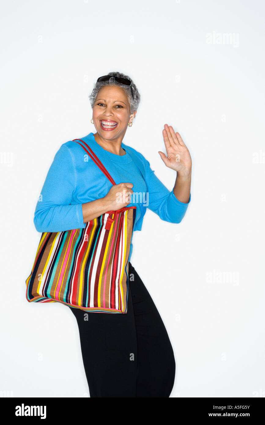 African American mature adult female holding big purse Stock Photo - Alamy
