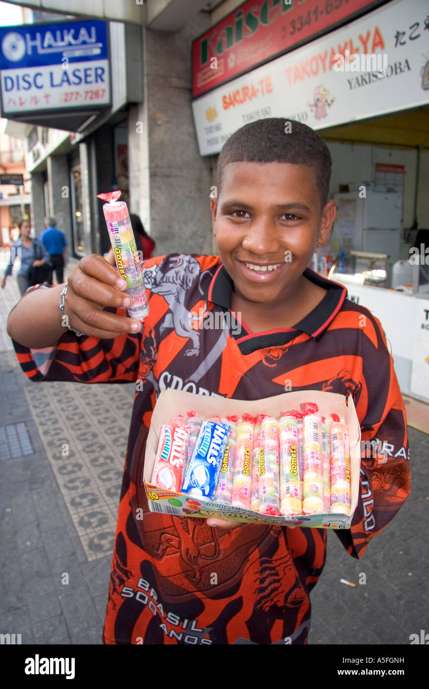 A boy selling candy on the street in the Liberdade asian section of Sao ...