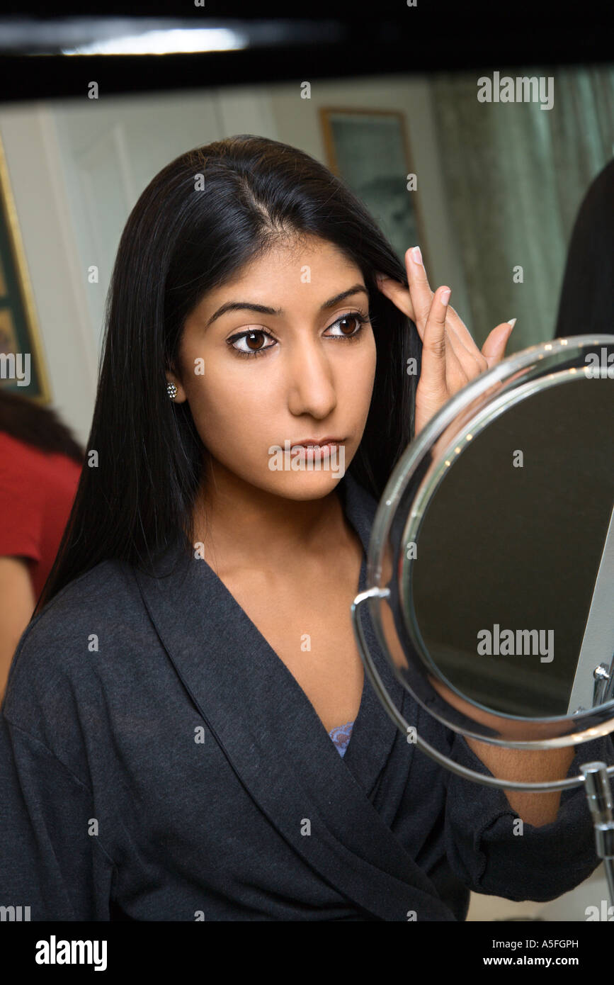 Close up of Asian Indian young woman looking in mirror primping Stock ...