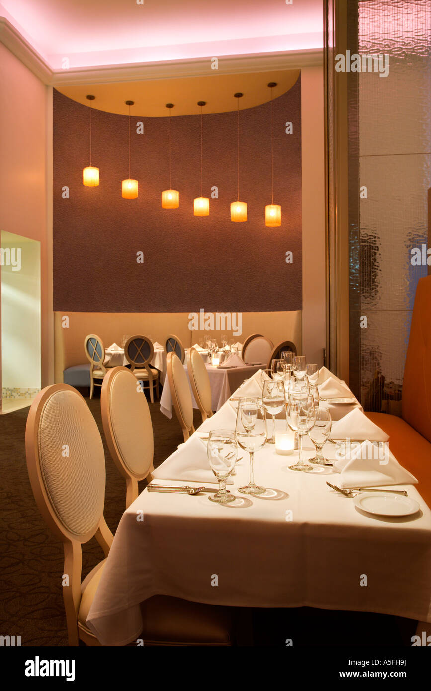 Long table in restaurant with place settings Stock Photo - Alamy