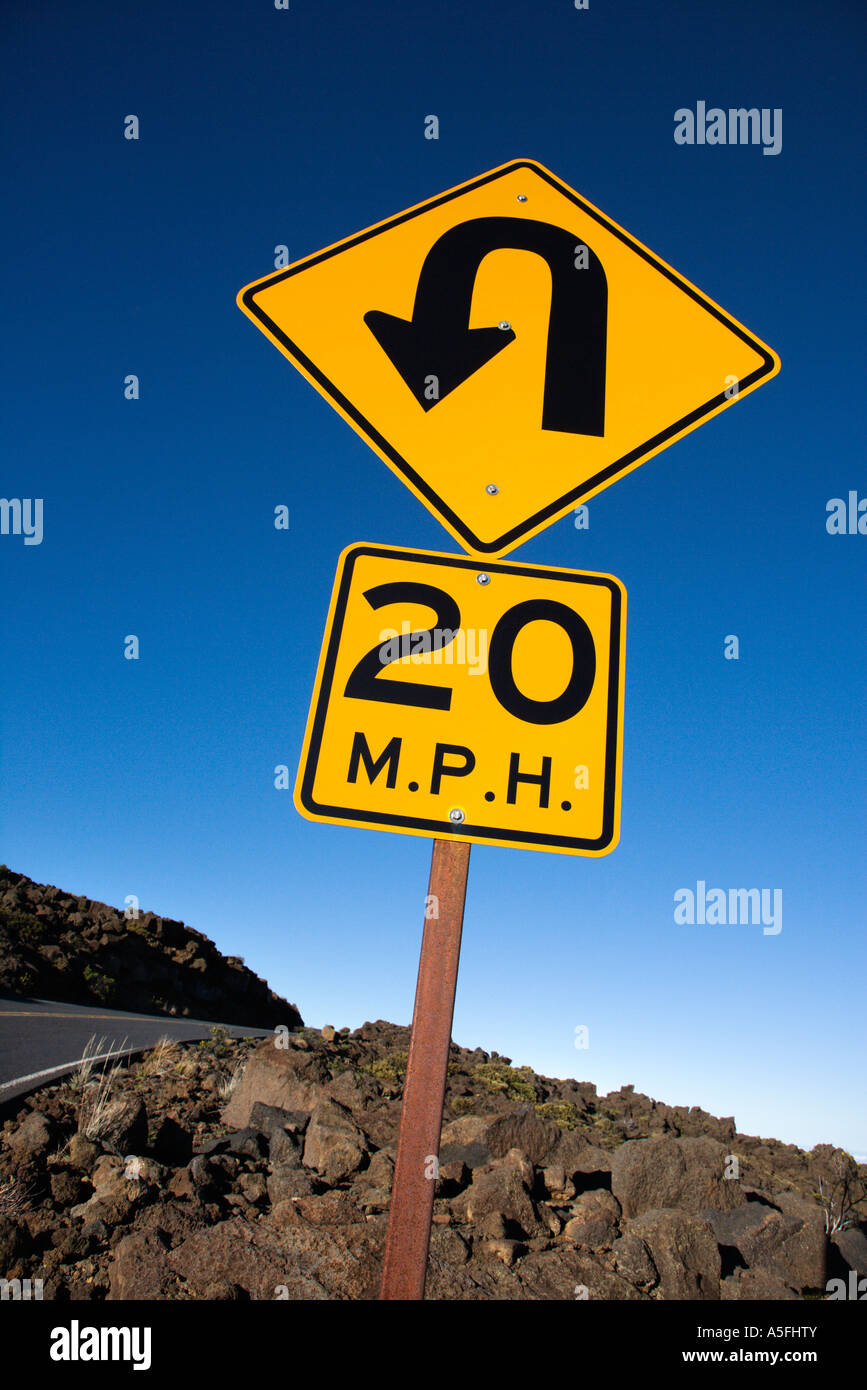 Warning road sign indicating curve and speed limit in Haleakala ...