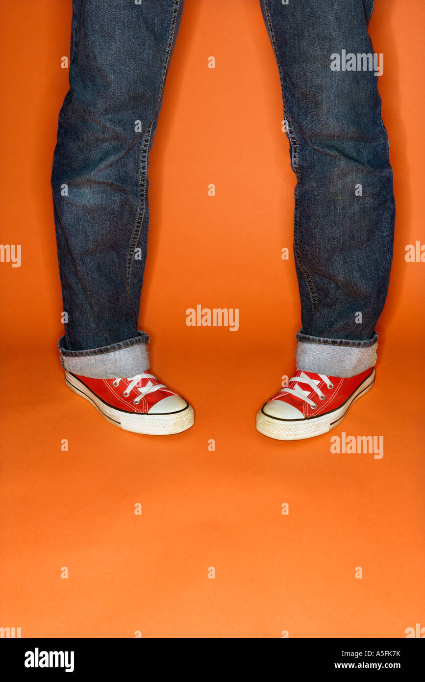 Person in jeans and sneakers with feet turned inward Stock Photo - Alamy