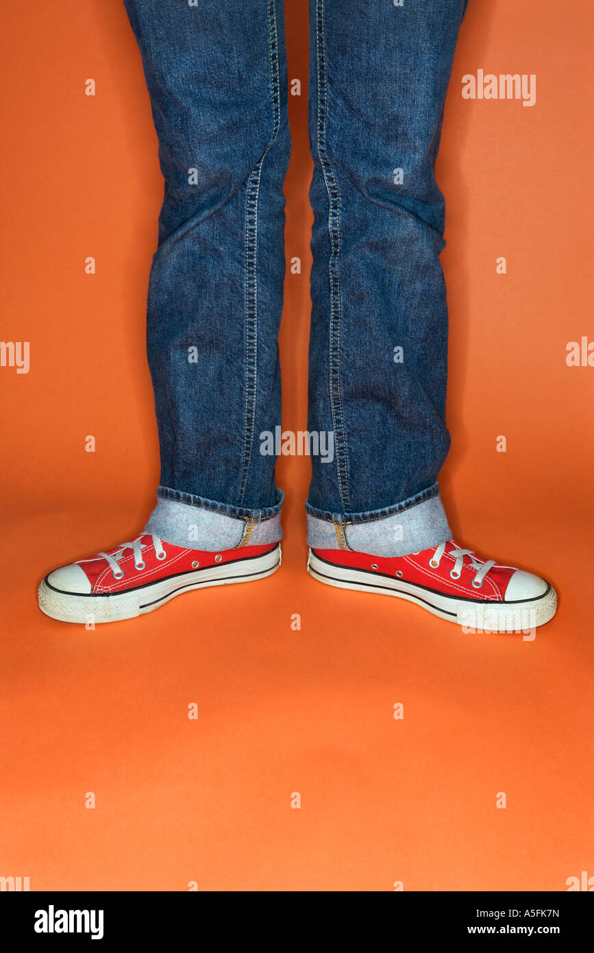 Person in jeans and sneakers with feet turned outward Stock Photo - Alamy