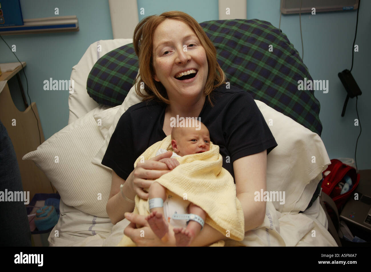 A new mother in a hospital ward bed showing her new born baby boy Stock ...