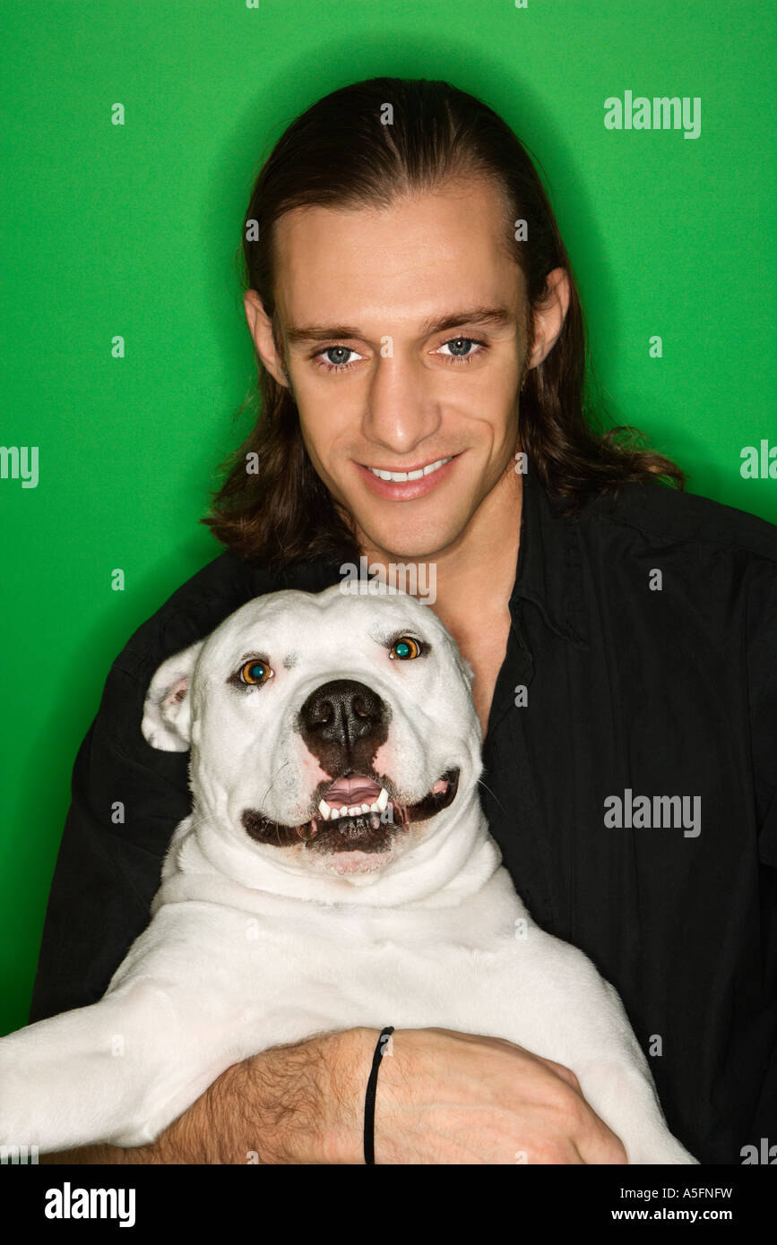 Caucasian mid adult man holding white Pit Bull on lap Stock Photo - Alamy