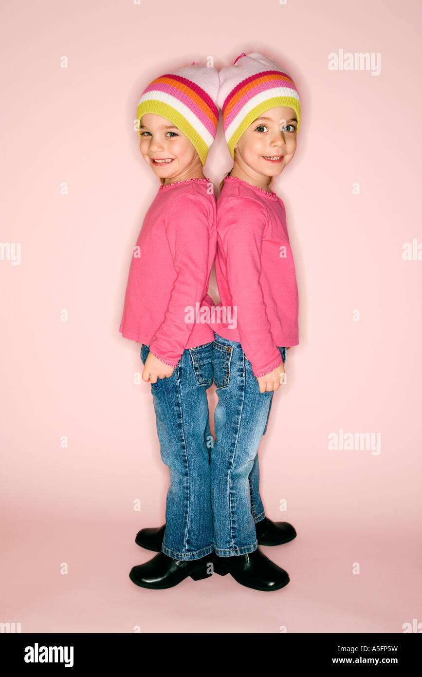 Young female twin Caucasian children standing back to back Stock Photo ...