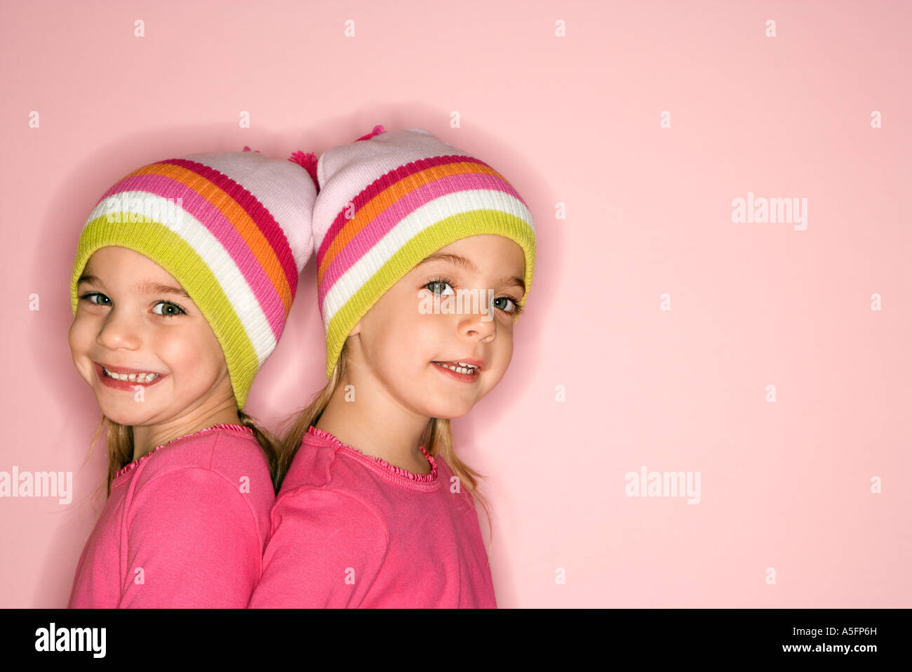 Young female twin Caucasian children standing back to back Stock Photo ...