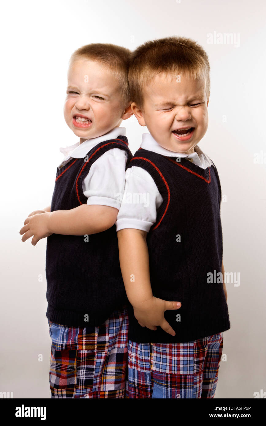 Caucasian twin boys crying standing against white background Stock ...