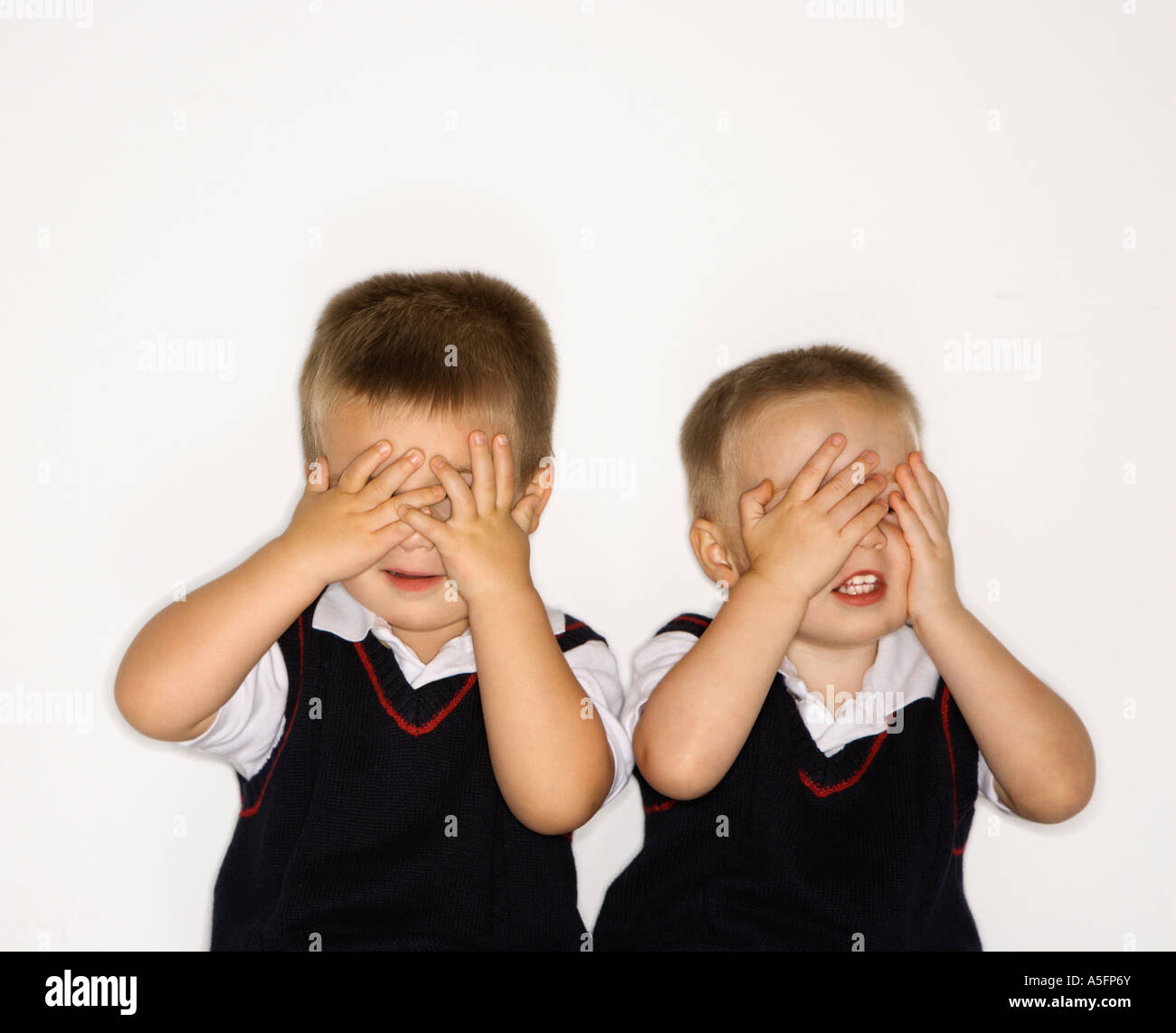 Caucasian male children twins with hands over eyes Stock Photo - Alamy