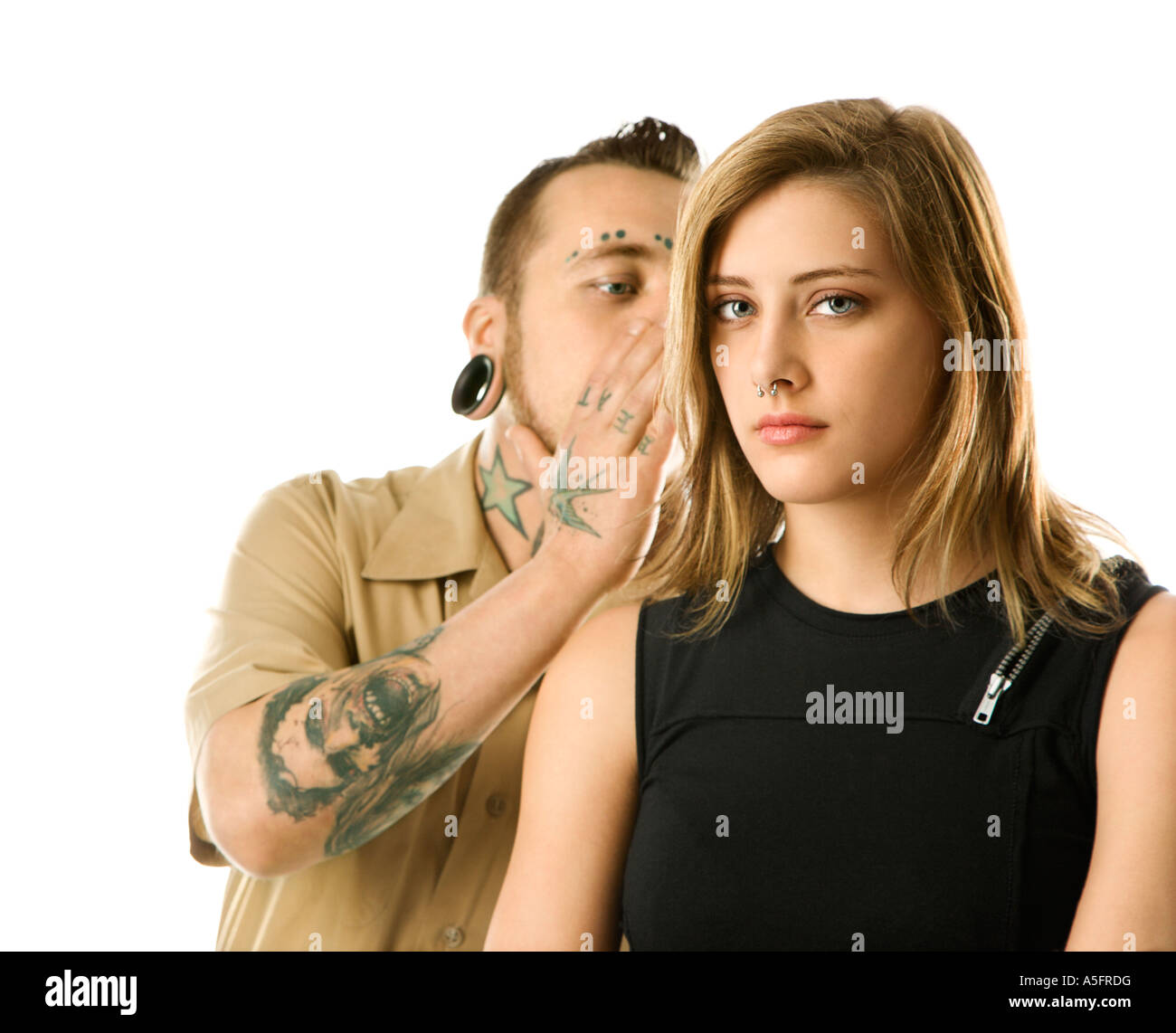 Caucasian mid adult man whispering into ear of teen female Stock Photo ...