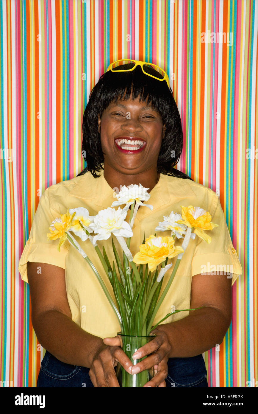 African American mid adult woman laughing holding flowers Stock Photo ...