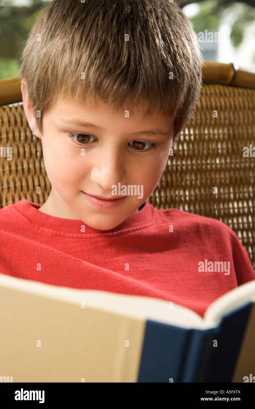 Caucasian pre teen boy reading book Stock Photo - Alamy