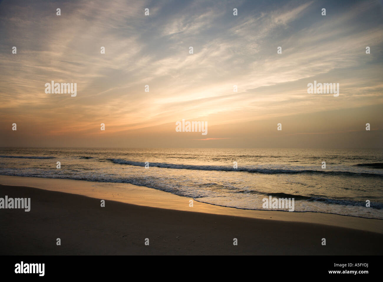 Ocean waves lapping on the shore at sunset Stock Photo - Alamy